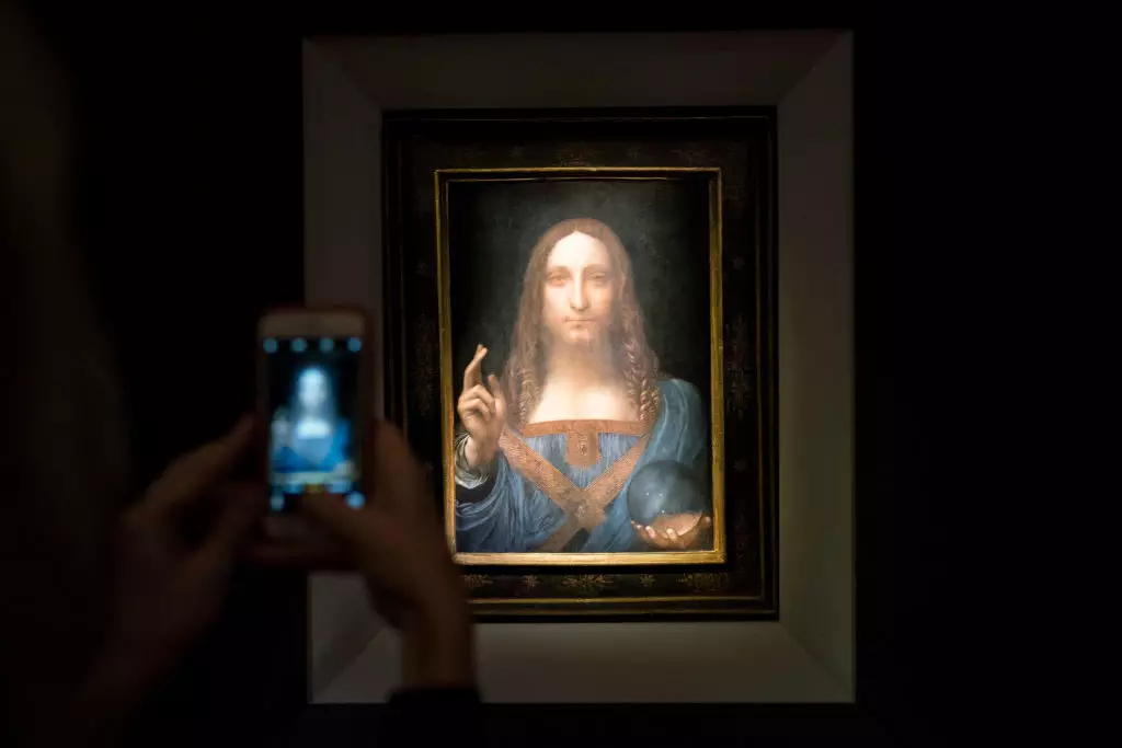 Isang bisita ang kumukuha ng larawan ng painting na 'Salvator Mundi' ni Leonardo da Vinci sa Christie's New York. (Drew Angerer/Getty Images)