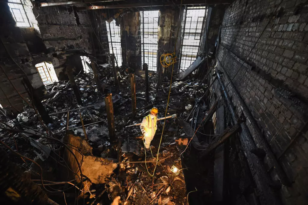 Forenzní archeolog Owen Godbert se 18. listopadu 2014 ve skotském Glasgow prodírá popelem z požárem poškozené knihovny Mackintosh na Glasgow School of Art. Foto s laskavým svolením Jeff J Mitchell/Getty Images.