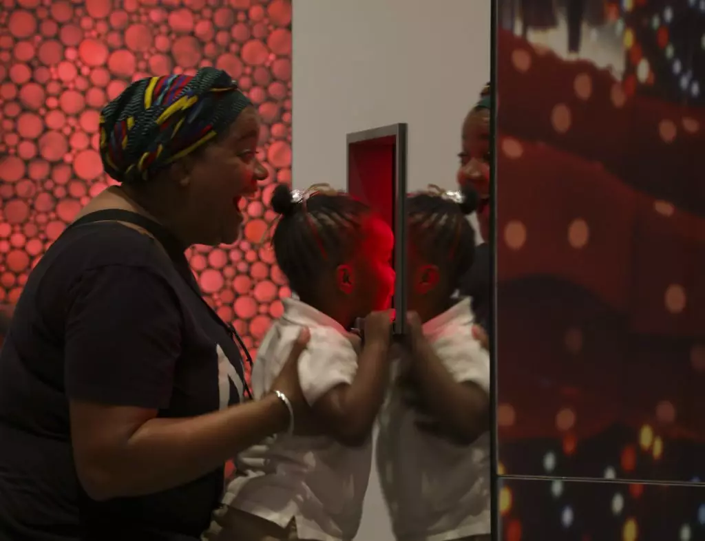 Hirshhorn Museum-vizitantoj admiras la laboron de Kusama, (2017). Foto de Cathy Carver. Ĝentileco de la Smithsonian.