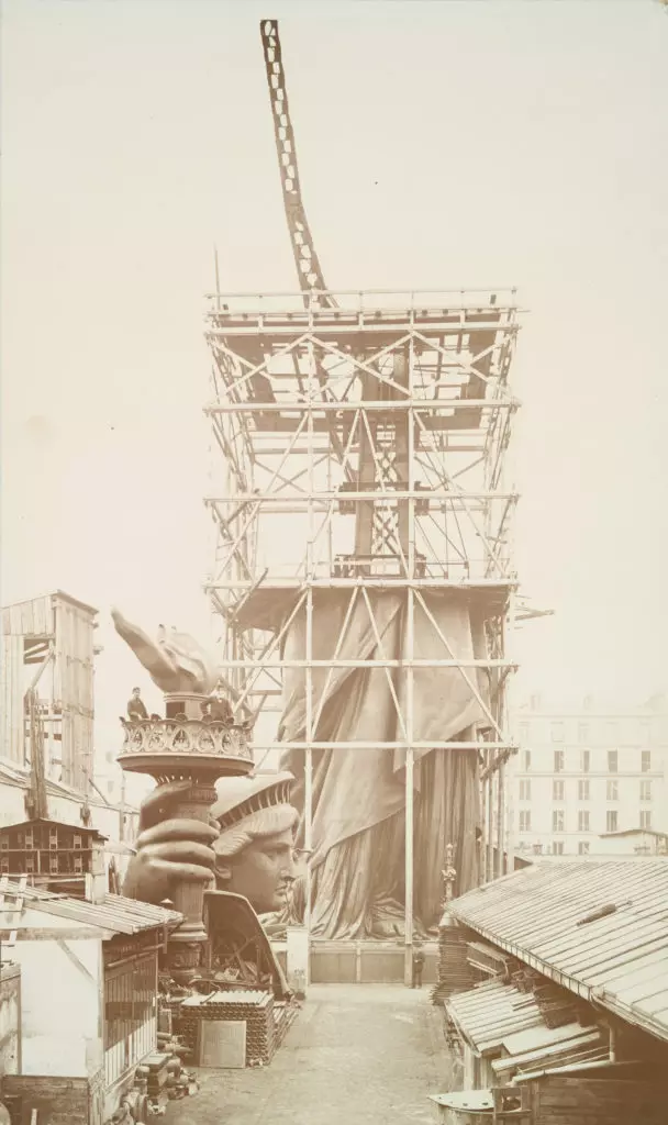 I-Assemblage of the Statue of Liberty in Paris, ebonisa ingxenye engezansi yesifanekiso emiswe ngaphansi kwesikafula, ikhanda kanye nethoshi ezinyaweni zaso (circa 1883). Isithombe sika-Albert Fernique, ngenhlonipho ye-New York Public Library.