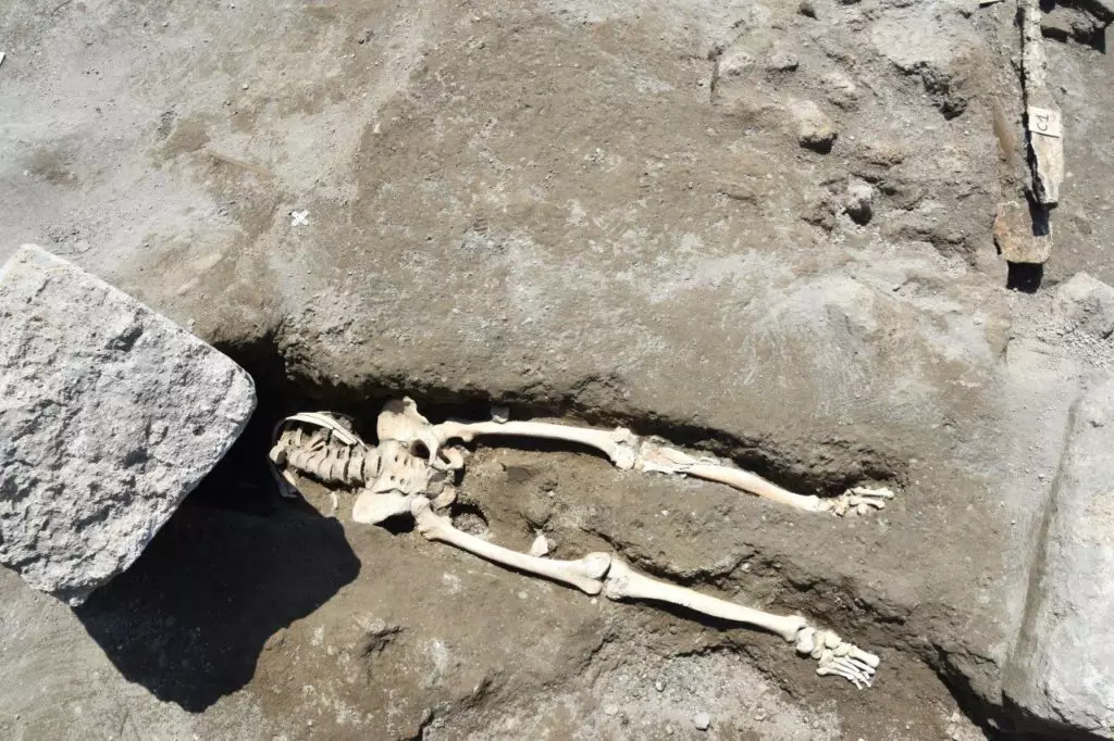 Mifupa hii ya mtu aliyeuawa na mwamba unaoanguka wakati akikimbia mlipuko wa Vesuvius iligunduliwa hivi karibuni kwenye tovuti ya kiakiolojia ya Pompeii. Picha kwa hisani ya Soprintendenza Archeologica di Pompei.