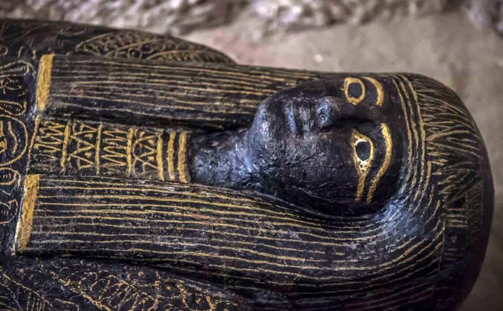 Sarcophagus madow oo alwaax ah oo la xardhay oo lagu dhejiyay go'yaal dhalaalaya oo ay heleen hawlgalkii qadiimiga Masar ee goobta Tomb TT28, ama Thaw-Irkhet-If, oo ku taal Al-Assasif necropolis oo ku taal daanta galbeed ee Niil waqooyiga magaalada koonfurta Masar ee Luxor. Sawirka waxaa leh Khaled Desouki/AFP/Getty Images.