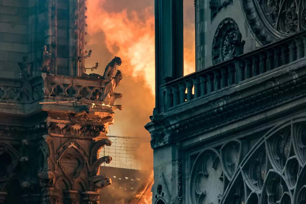 Moto na moshi unatanda kuzunguka ngome zinazopamba paa na kingo za Kanisa Kuu la Notre-Dame mjini Paris mnamo Aprili 15, 2019. Picha na Thomas Sansom/AFP/Getty Images.