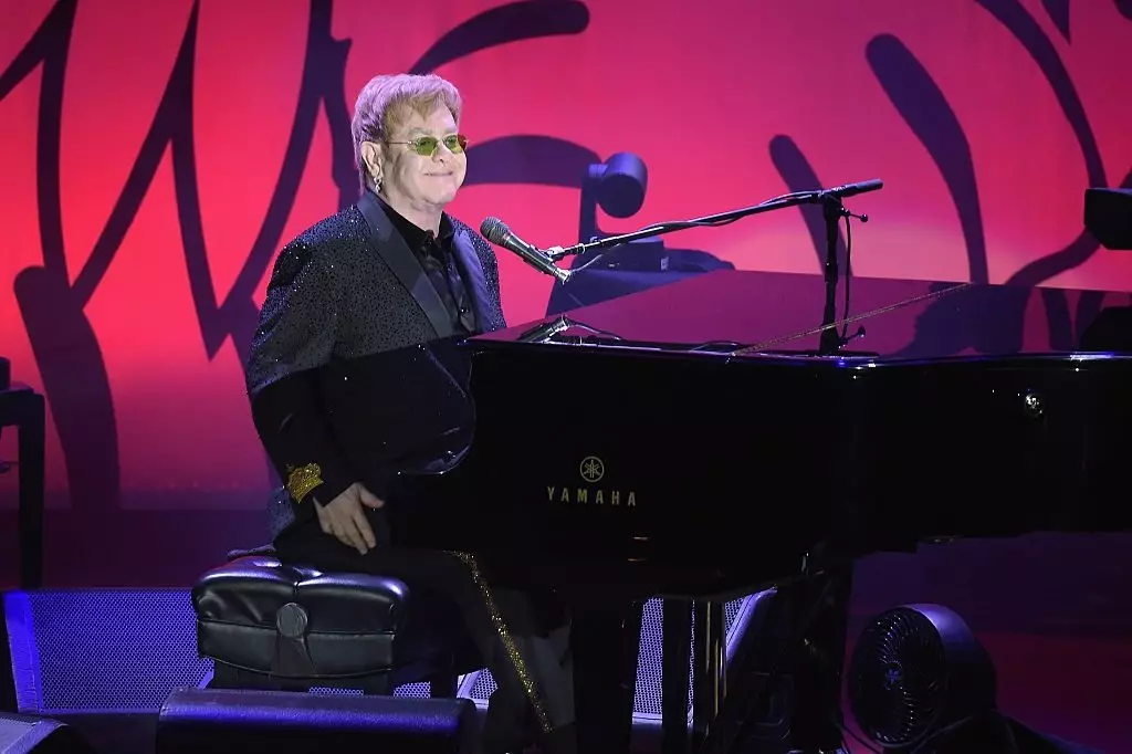 Feidhmíonn Elton John ag Hot Pink Party de chuid an Fhondúireacht um Thaighde Ailse Cíche ag Óstán Waldorf Astoria ar 12 Aibreán, 2016 i Nua-Eabhrac. Grianghraf Theo Wargo/Getty Images don BCRF.