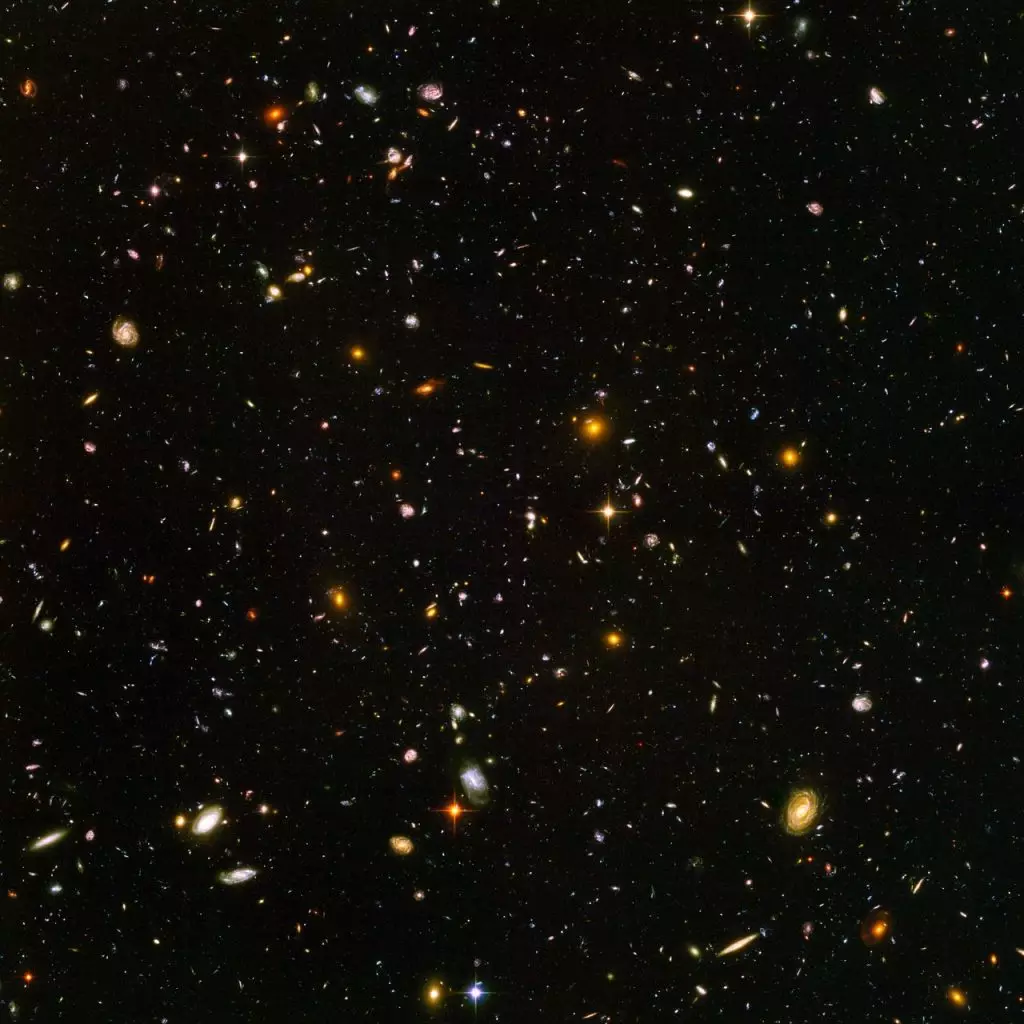 This view of nearly 10,000 galaxies is called the Hubble Ultra Deep Field. The snapshot includes galaxies of various ages, sizes, shapes, and colors. The smallest, reddest galaxies, about 100, may be among the most distant known, existing when the universe was just 800 million years old. The nearest galaxies—the larger, brighter, well-defined spirals and ellipticals—thrived about one billion years ago, when the cosmos was 13 billion years old. The image required 800 exposures taken over the course of 400 Hubble orbits around Earth, pointed at a patch of sky where astronomers had not previously observed any stars. The total amount of exposure time was 11.3 days, taken between September 24, 2003 and January 16, 2004. Courtesy of NASA, ESA, and S. Beckwith (STScI) and the HUDF Team, Creative Commons <a href=http://creativecommons.org/licenses/by/4.0/ target=