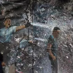 Un dipinto in un luogo di protesta di Hong Kong mostra la polizia antisommossa che usa spray al peperoncino contro manifestanti pro-democrazia. Foto: AFP.