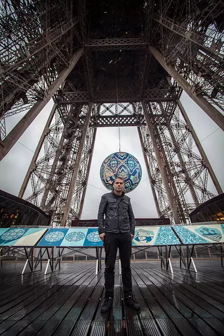 Der Künstler posiert vor seiner neuesten Installation auf dem Eiffelturm in Paris. Foto: Tapete