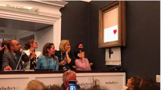 Moun k ap gade yo sezi reyaji lè Ti fi Banksy a ak yon balon ap detwi tèt yo nan Sotheby a.