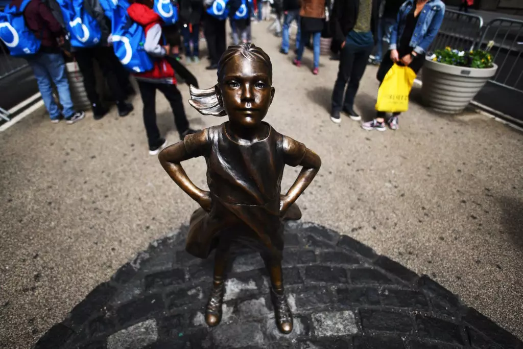 Kristen Visbalen Fearless Girl estatua Arturo DiModicaren Charging Bull eskultura enblematikoaren aurrean dago turistek argazkiak ateratzen dituzten bitartean. DiModica-k salatu du Fearless Girl-ek bere copyrighta urratzen duela, bere mezu artistikoa desitxuratzen duela eta beste leku batera eraman behar dela. Jewel Samad/AFP/Getty Images-en adeitasuna.