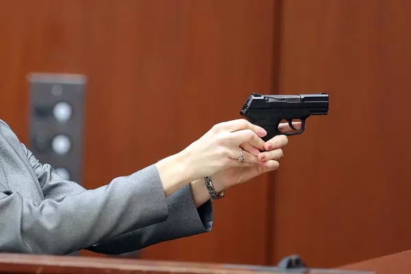 L'analyste des armes à feu Amy Siewert du Florida Department of Law Enforcement montre au jury comment l'arme de George Zimmerman peut être tirée. Avec l'aimable autorisation de Jacob Langston-Pool/Getty Images.