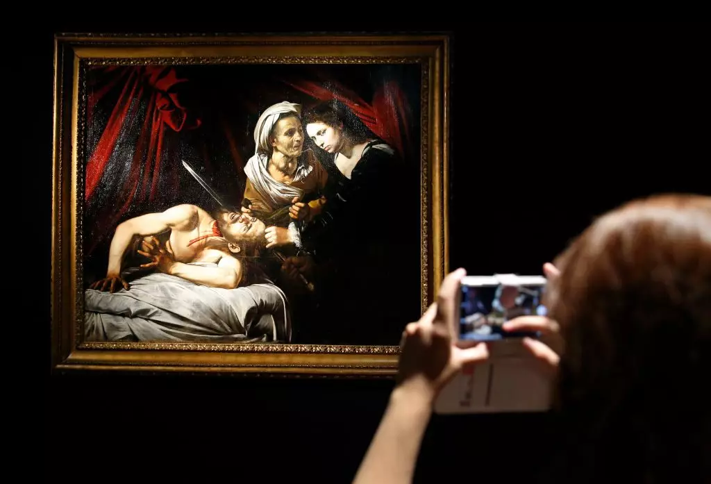 Posjetitelj slika Caravaggiovu sliku 'Judita odrubljuje glavu Holofernu' (1607.) u aukcijskoj kući Drouot 14. lipnja 2019. u Parizu, Francuska. Fotografija Chesnot/Getty Images.