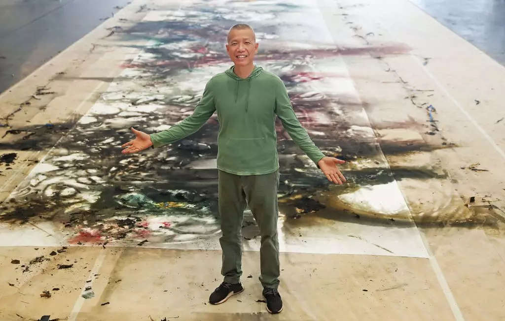 Современиот уметник Cai Guo-Qiang позира откако создаде ново дело од оган и барут; Цртеж од 31 метар барут на свила, со наслов Transience II (Божур) (2019). Фотографија на Скот Барбур/Гети Имиџис за NGV.