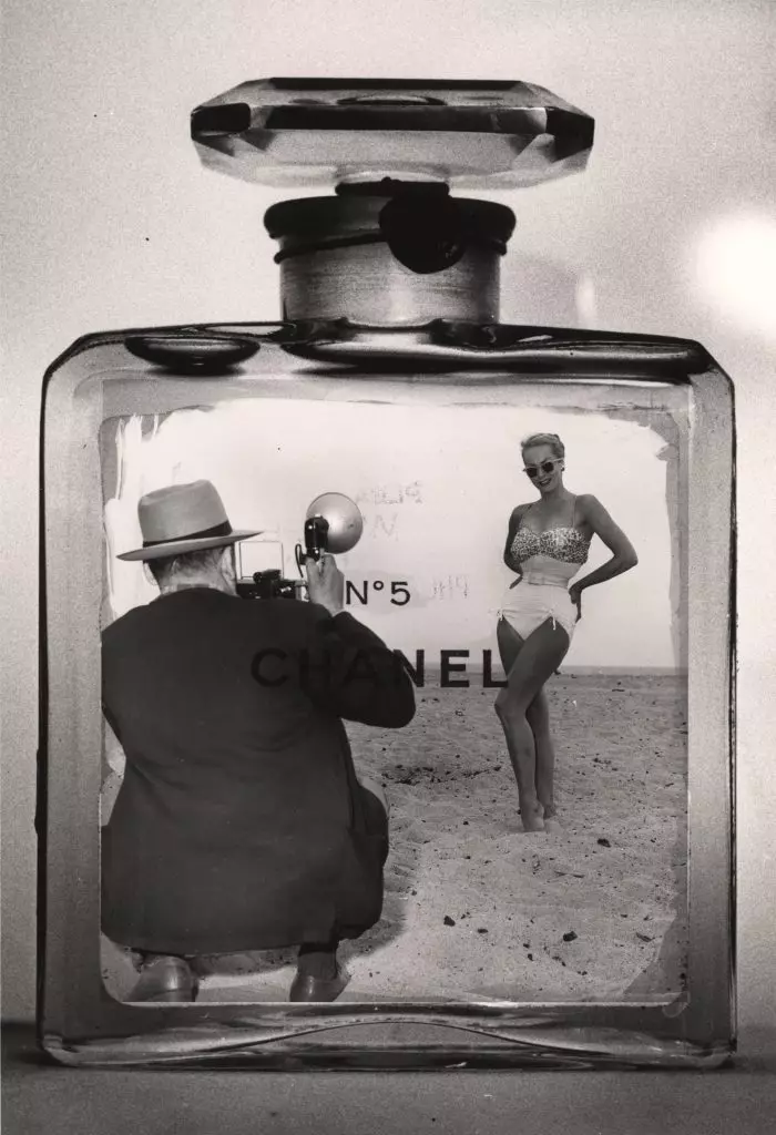 Fotomontaje del fotógrafo estadounidense Weegee (1899 - 1968) tomando una fotografía de una mujer en traje de baño dentro de una botella de Chanel No. 5 a fines de la década de 1950. (Foto de Weegee (Arthur Fellig)/Centro Internacional de Fotografía/Getty Images)