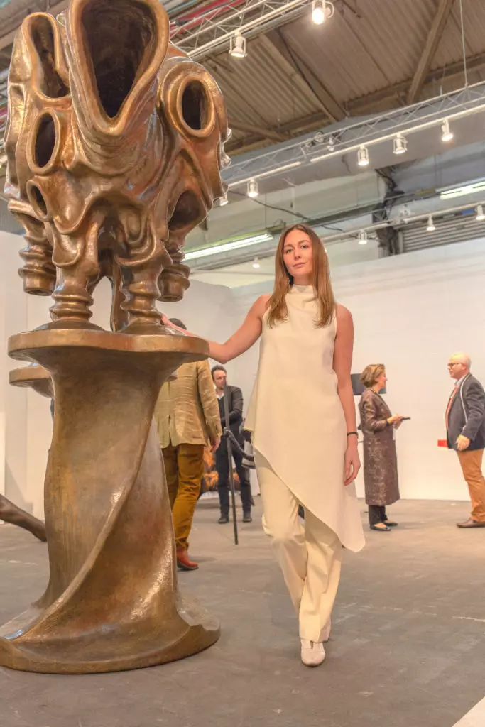 Ashlee Harrison naast Atelier Van Lieshout's