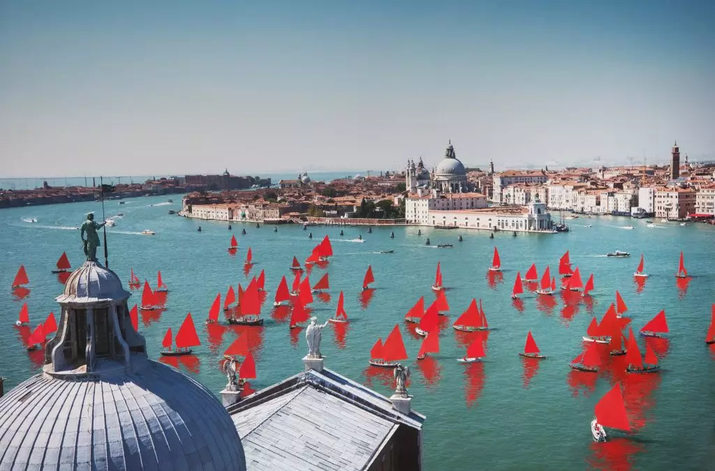 Melissa McGill, Venedik'te yelken veya kürekle gezinmeyi önerdi. 2019'da sanatçının Red Regatta'sı, Associazione Vela al Terzo Venezia ile işbirliği içinde lagününü ve kanallarını elle boyanmış kırmızı yelkenli geleneksel yelkenli teknelerle etkinleştirdi. Sanatçının ve Mazzoleni'nin izniyle.