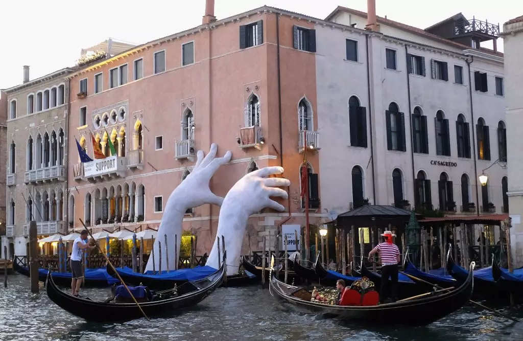 Lorenzo Quinn, Msaada, huko Venice, Italia, Mei 19, 2017. Mchoro huo, ulio na mikono miwili iliyoinua Hoteli ya Ca' Sagredo, ulikuwa sehemu ya Maonyesho ya 57 ya Kimataifa ya Sanaa ya Venice Biennale, na ilikusudiwa kuangazia hali ya hewa. mabadiliko. Picha: Adam Berry/Getty Images.