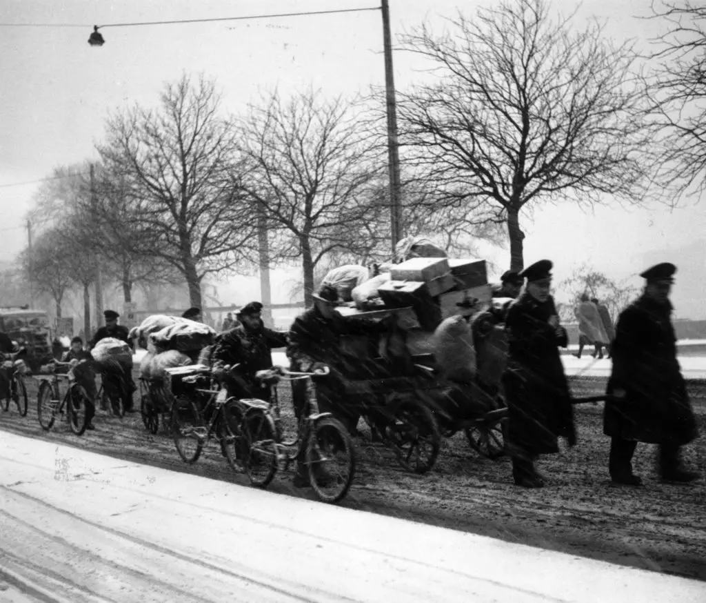 Tyske flyktninger etter slutten av andre verdenskrig i Europa passerer Hamburg under en snøstorm, og drar vogner stablet høyt med eiendelene sine. (Foto av Keystone/Getty Images)