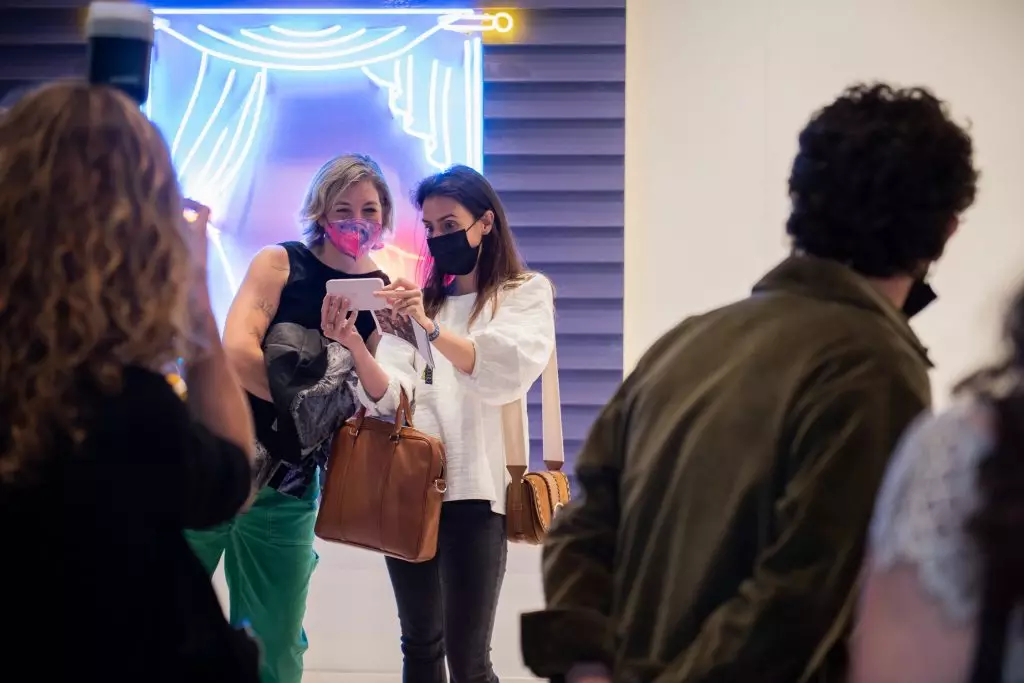 Invitados tomándose selfies frente a una obra de arte de Alex Da Corte.