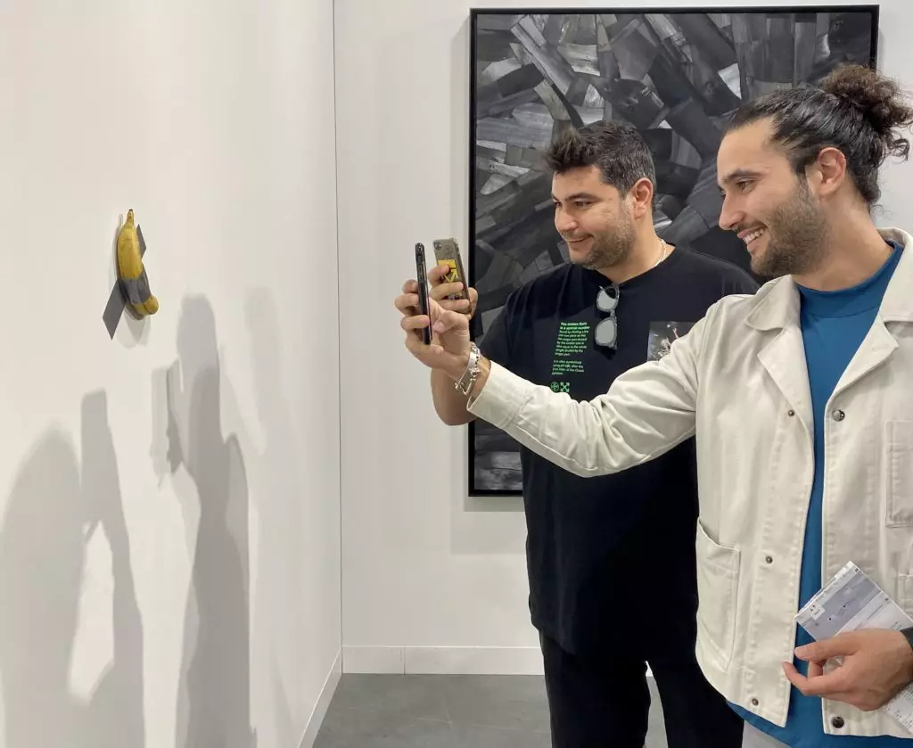 Ndjekësit e panaireve bëjnë fotografi të komedianit të Maurizio Cattelan, për shitje nga Perrotin në Art Basel Miami Beach. Foto nga Sarah Cascone.