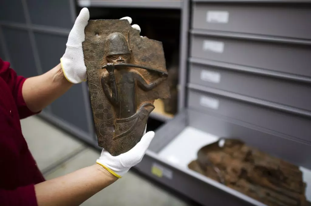 Isang maliit na brass relief plate mula sa Benin Empire na naglalarawan ng mga royal hornblower mula sa isang drawer ng rolling shelf sa depot ng Dresden State Art Collections sa Dresden. Larawan: Arno Burgi/picture alliance sa pamamagitan ng Getty Images.