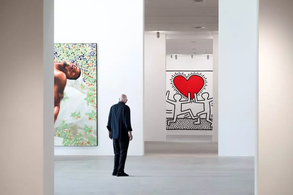 Don Rubell mbele ya kazi na Kehinde Wiley na Keith Haring kwenye Jumba la Makumbusho la Rubell. Picha kwa hisani ya Jumba la kumbukumbu la Rubell.