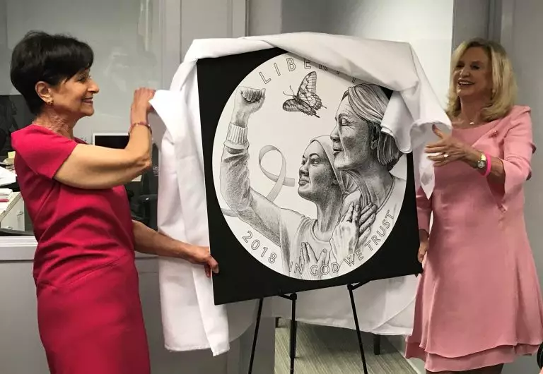 New York Congresswoman Carolyn Maloney en Borskankernavorsingstigting, president en uitvoerende hoof, Myra Biblowit, onthul die wenontwerp deur Emily Damstra vir die Borskankerbewustheid-herdenkingmuntontwerpkompetisie. Foto met vergunning van die Amerikaanse Munt.