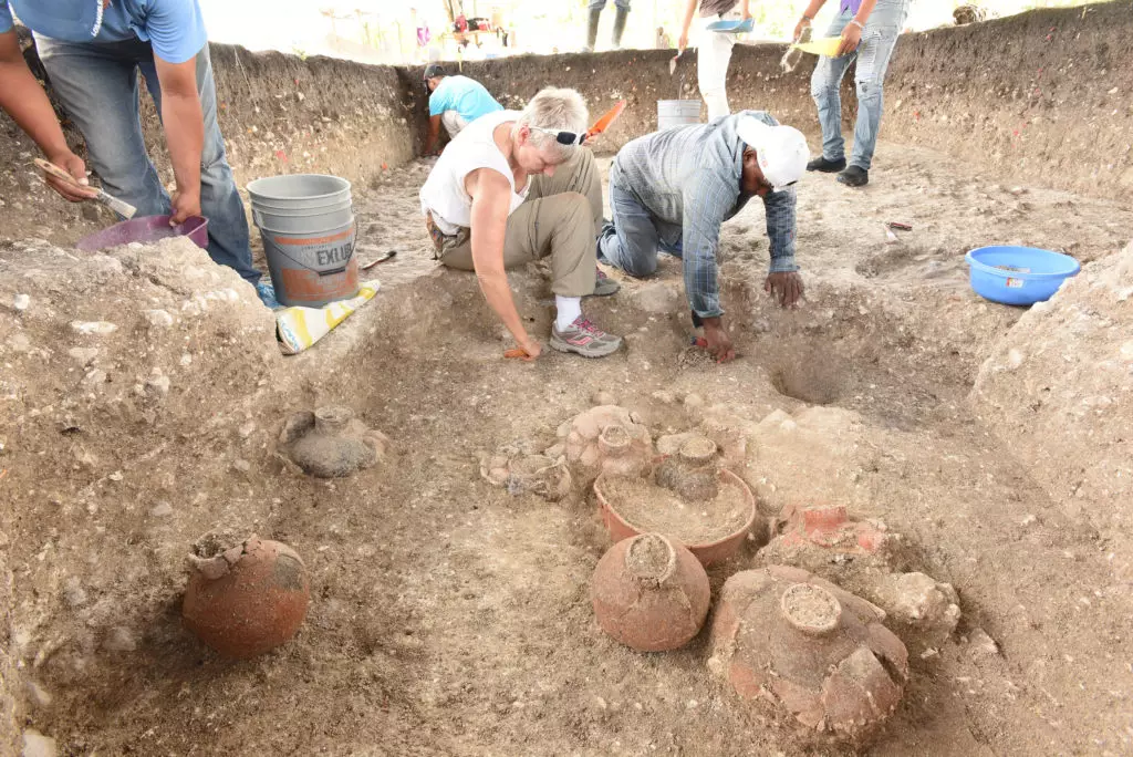 Daniela Triadan (centro) escavando com múltiplos vasos cerâmicos na Aguada Fenix. Cortesia de Takeshi Inomata.