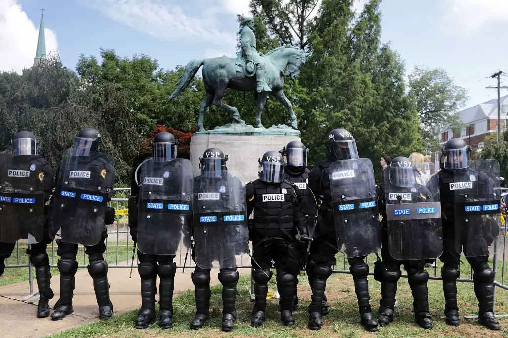 La police de l'État de Virginie en tenue anti-émeute se tient devant la statue du général Robert E. Lee avant de forcer les nationalistes blancs, les néo-nazis et les membres de la