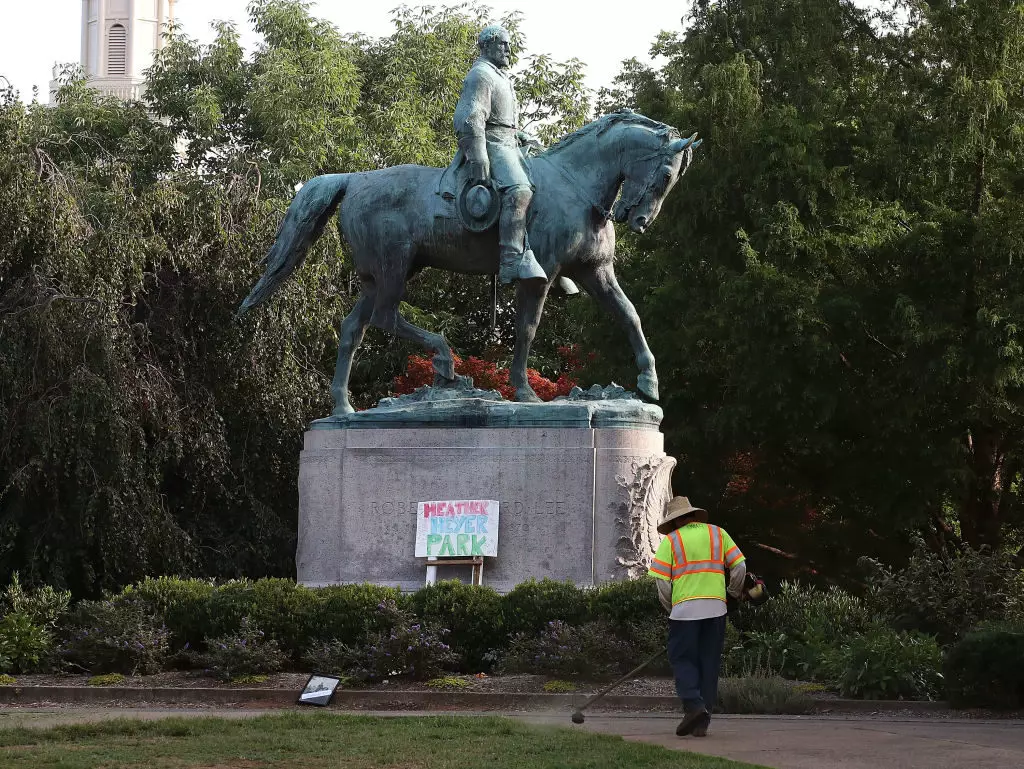 Un panneau fait maison qui dit "Heather Heyer Park" repose à la base de la statue du général confédéré Robert E. Lee qui se dresse au centre d'Emancipation Park le 18 août 2017 à Charlottesville, en Virginie. Photo de Mark Wilson/Getty Images.