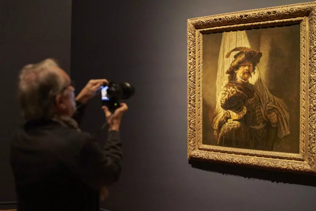 Vernisáž 'Holandského a AMSTERDAMU, HOLANDSKO - 11. OKTÓBRA: Návštevník odfotografuje obraz od Rembrandta The Standard-bearer počas výstavy v Rijksmuseum, 11. októbra 2019 v Amsterdame v Holandsku. Výstava, partnerstvo medzi Rijksmuseum a Museo Nacional del Prado v Madride, skúma prepojenie medzi holandskou a španielskou maliarskou tradíciou. Getty Images.