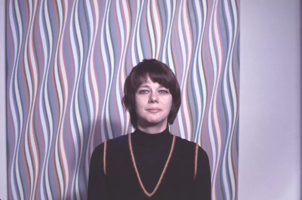 Portret van de Britse op artiest Bridget Riley met een deel van haar werk, 1975. Foto door Jack Mitchell/Getty Images.