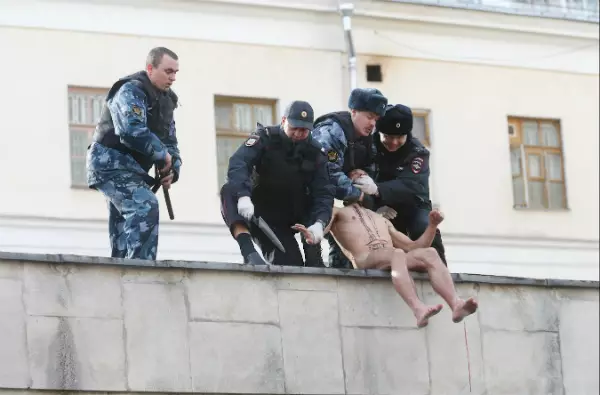 Pyotr Pavlensky motong daun ceulina, dina hateup pusat jiwa Serbsky di Moscow. Kinerja 2014 disebut Segregation. Poto ku Missoksana, Creative Commons Attribution-Share Alike 4.0 Lisensi internasional.