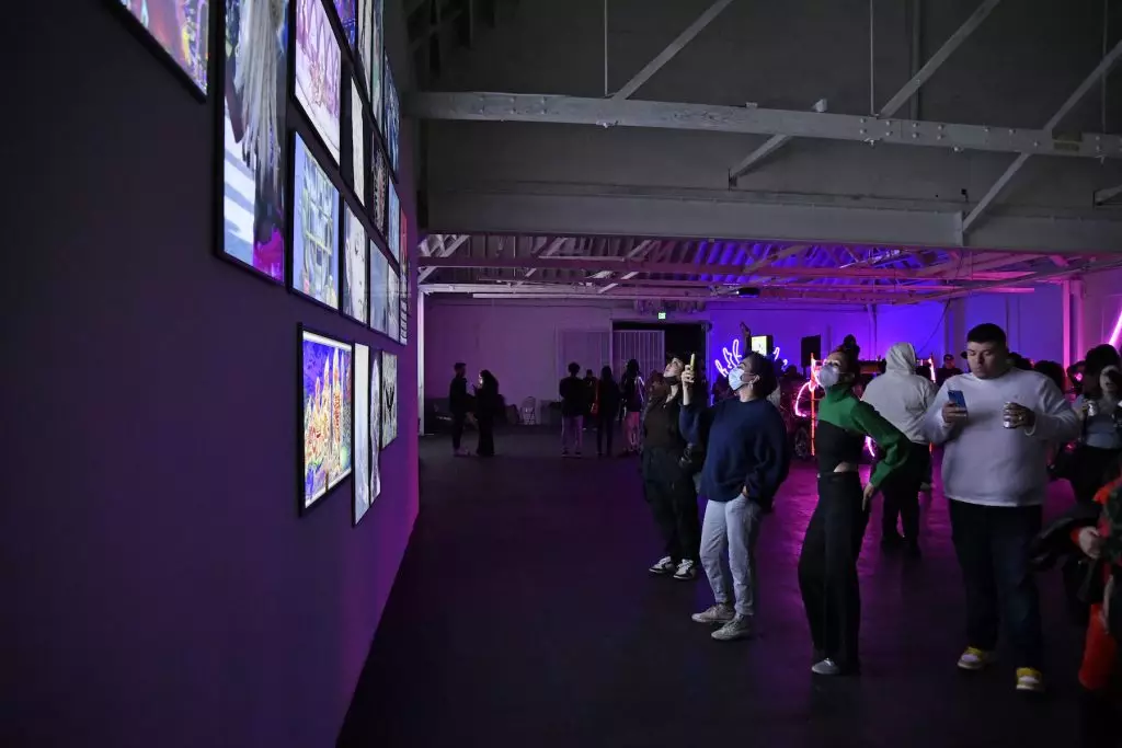 Un groupe de personnes regarde l'art numérique NFT lors de l'événement FRIEZE Week NFT pour