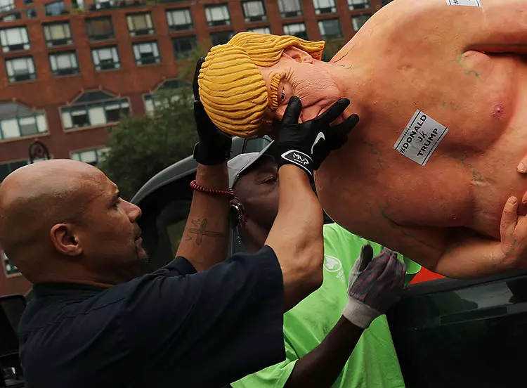 Aarbechter ewechzehuelen eng illegal opgeriicht Statu vun engem plakeg GOP Presidentschaftswalen Kandidat Donald Trump datt wossten am Union Square Park zu New York City 18. August 2016. Ugedriwwe vun Spencer Platt / Getty Biller.