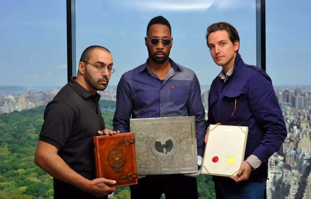 Hawak ng mga miyembro ng Wu-Tang Clan na sina Cilvaringz at RZA at Paddle8 founder Alexander Gilkes ang libro, kahon, at sertipikasyon na kasama ng