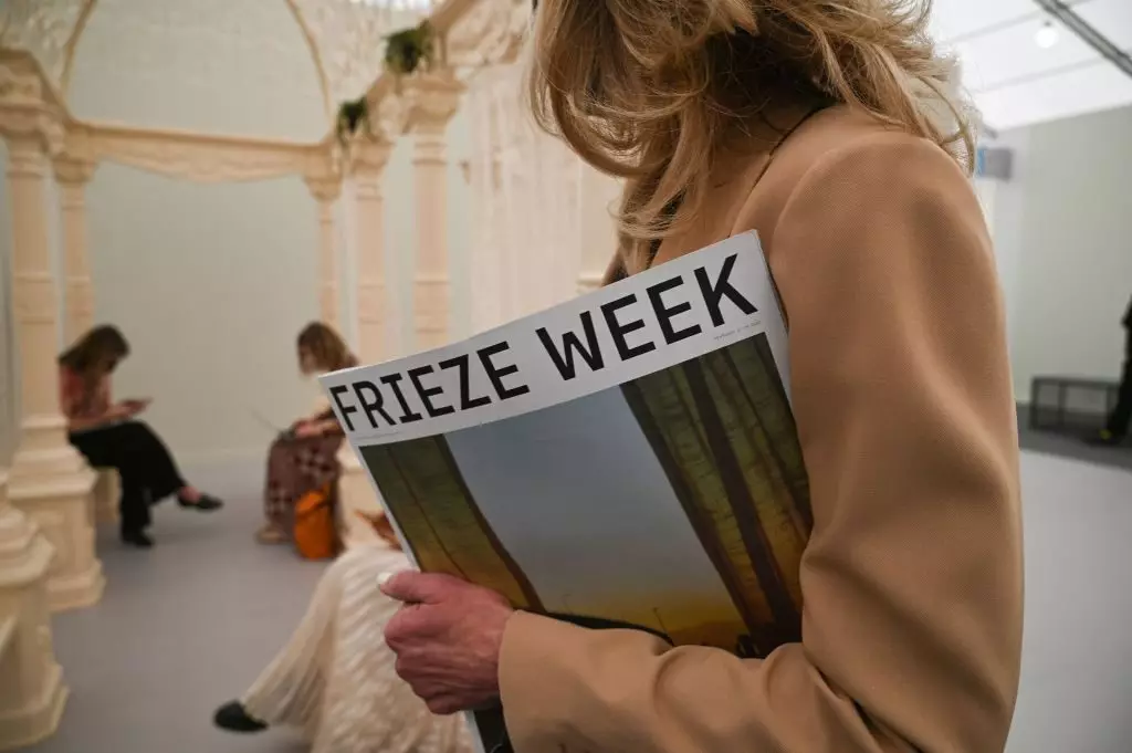 En Participant hält de Frieze Week Magazine um éischten Dag vu Frieze Los Angeles, enger féierender internationaler Konschtmesse, de 17. Februar 2022 zu Beverly Hills, Kalifornien. Foto: ROBYN BECK/AFP via Getty Images.