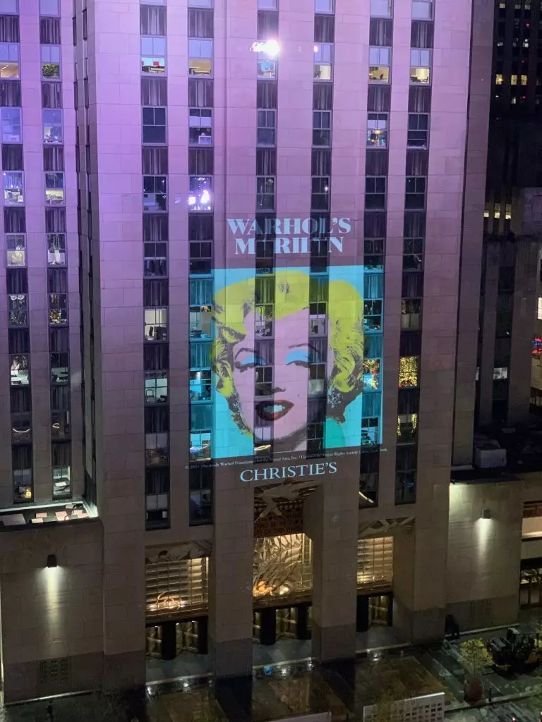 Projektionen af Andy Warhols Shot Sage Blue Marilyn (1964) på Rockefeller Center. Udlånt af Christie's.