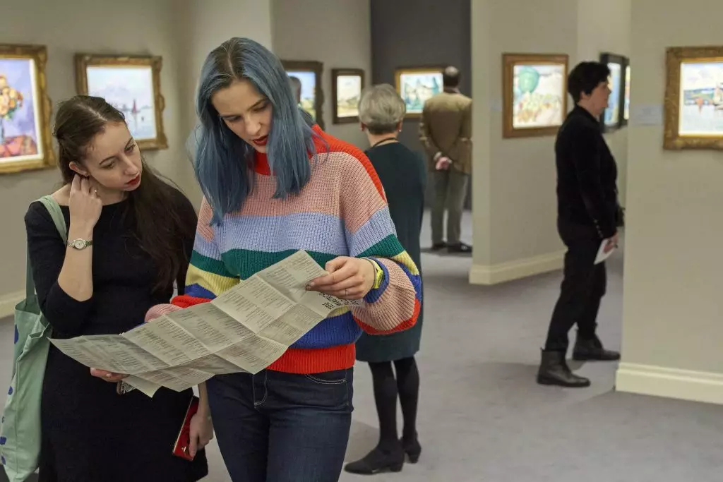 To av de besøkende ser på et kart med plasseringen av kunstgalleriene under TEFAF kunstmessen 7. mars 2020 i Maastricht, Nederland. (Bilde med tillatelse fra Getty Images.)